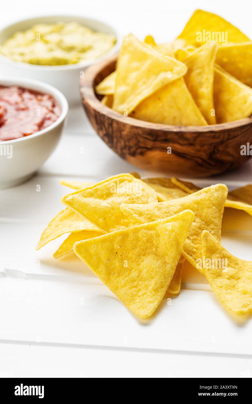 Corn nacho chips. Yellow tortilla chips on white table Stock Photo - Alamy