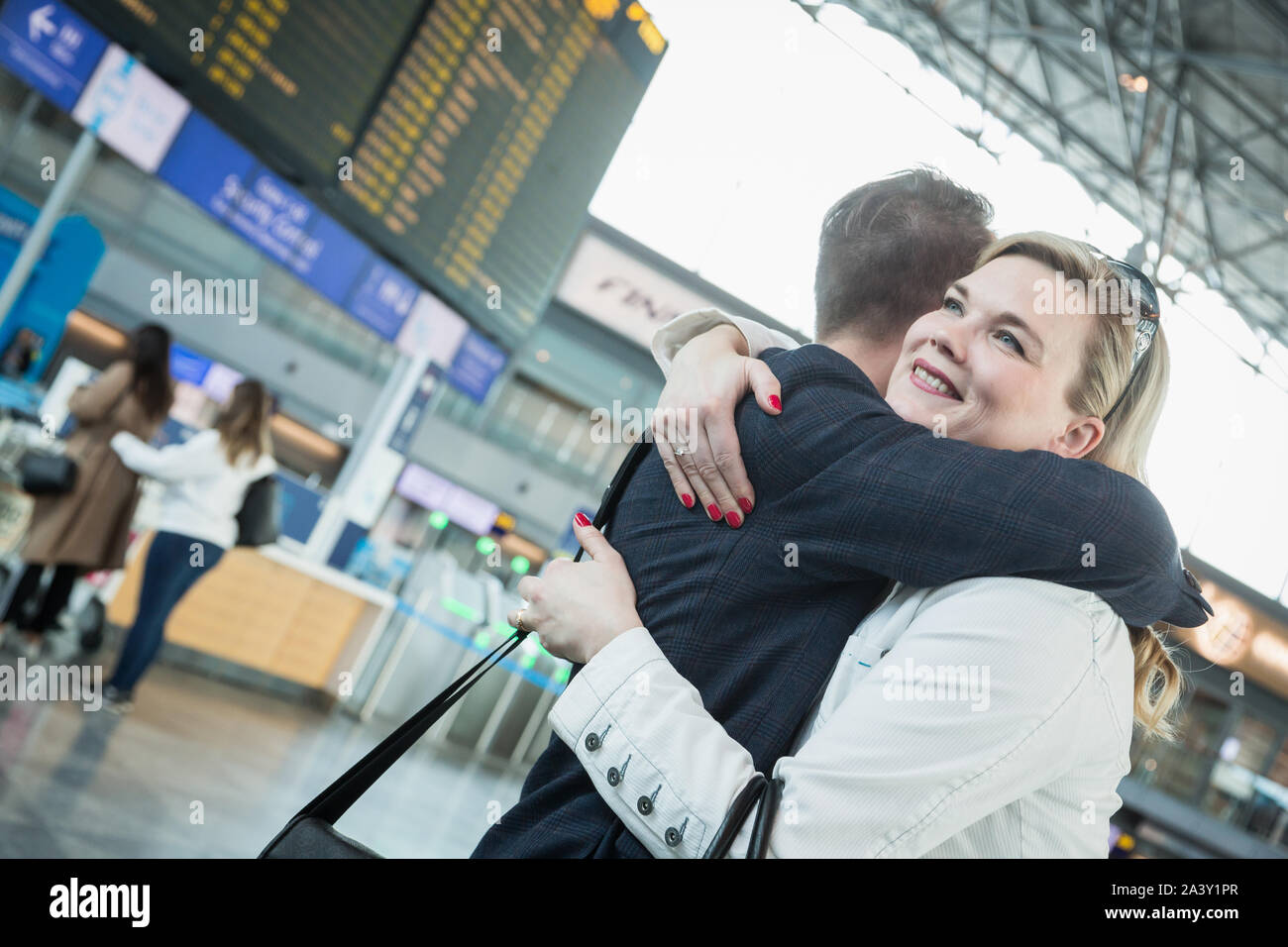 Woman and man passengers hugging each other at the airport Stock Photo ...