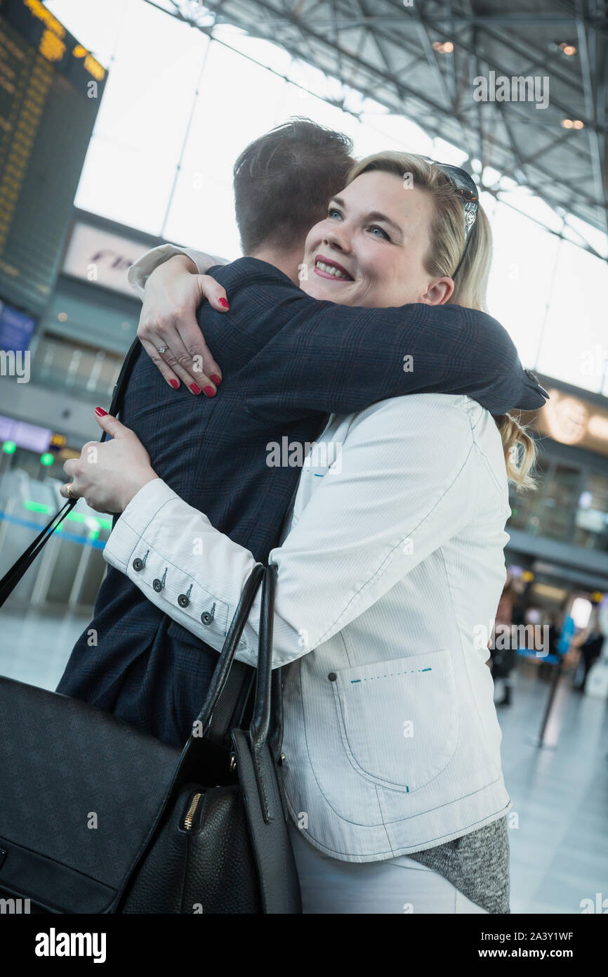 Woman and man passengers hugging each other at the airport Stock Photo ...