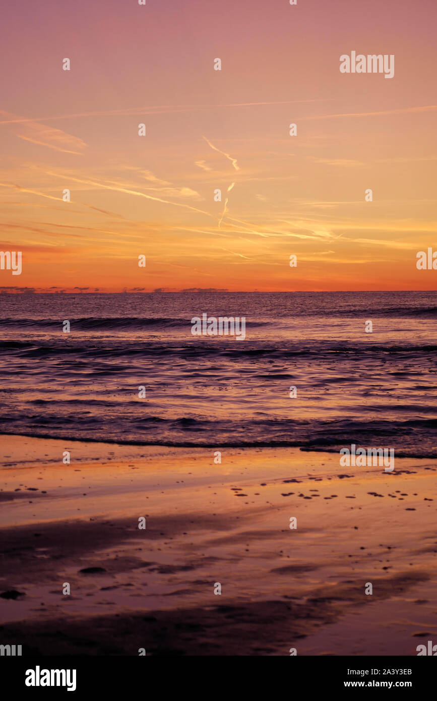 Sunset reflected in the sea at the beach in Texel, The Netherlands ...