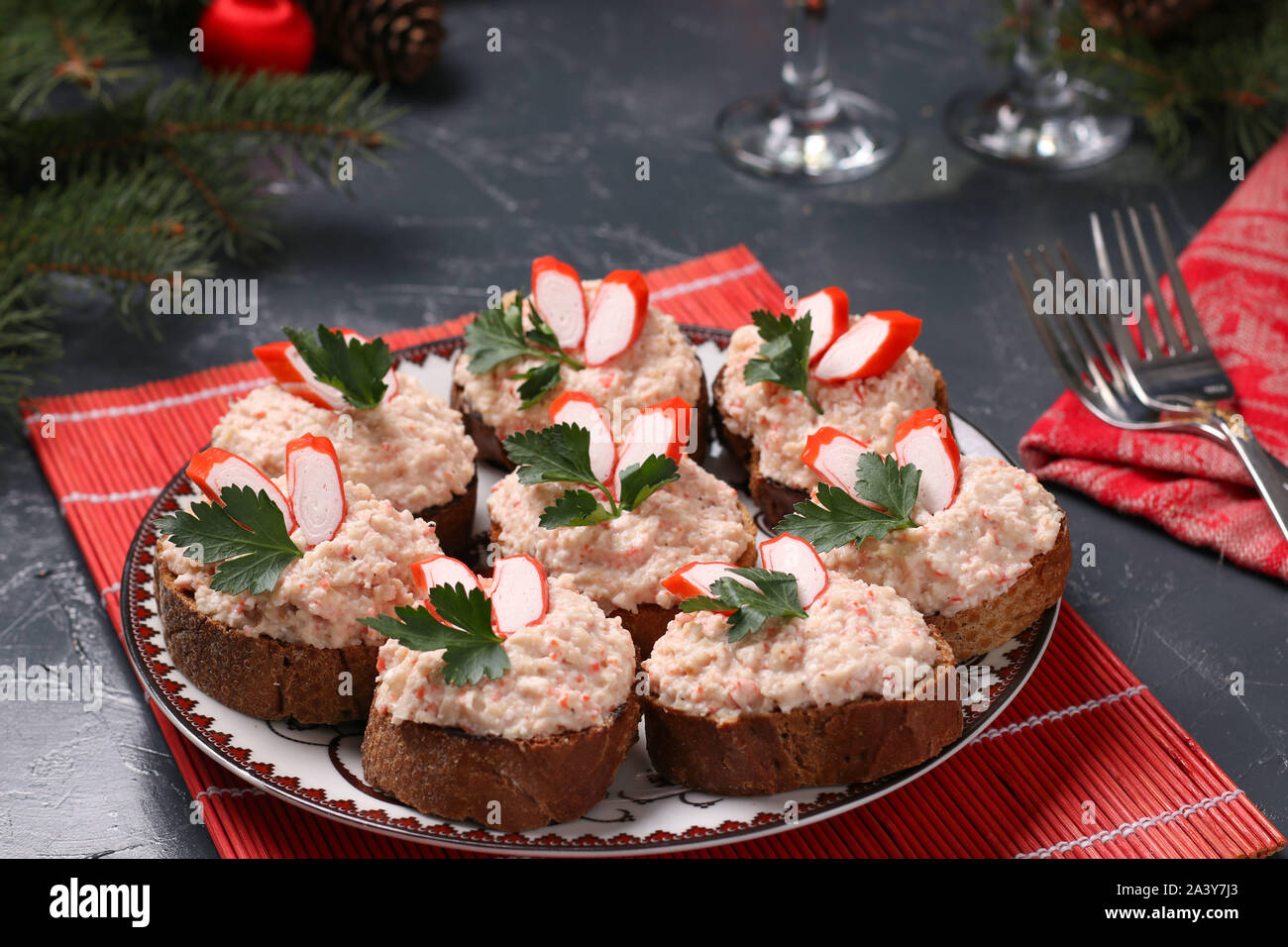 Canapes with cream cheese, crab sticks and beans on the dark background ...