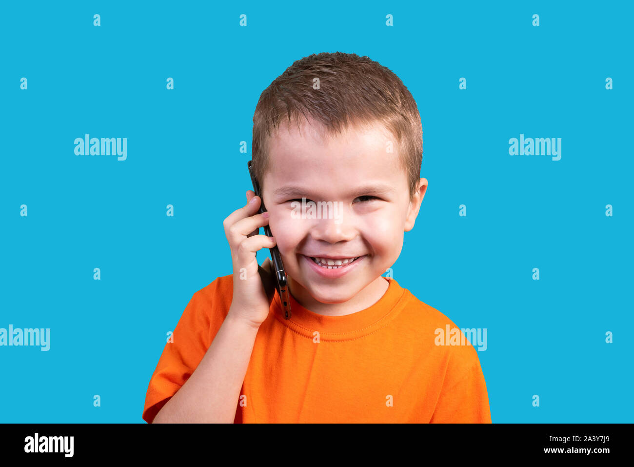Little boy is talking on the phone. Isolated on a blue background Stock ...