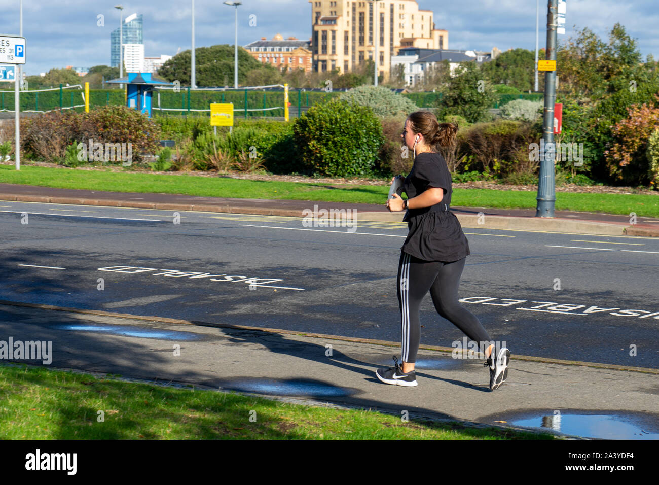 Woman jogging along roadside hi-res stock photography and images - Alamy