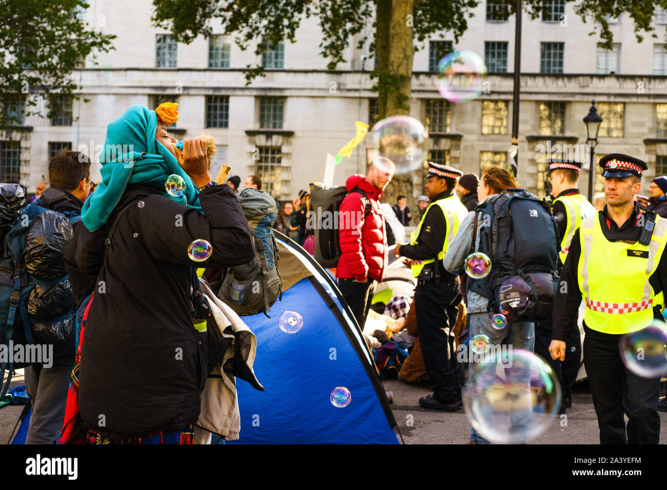 a woman blows bubbles to the police officers Stock Photo - Alamy