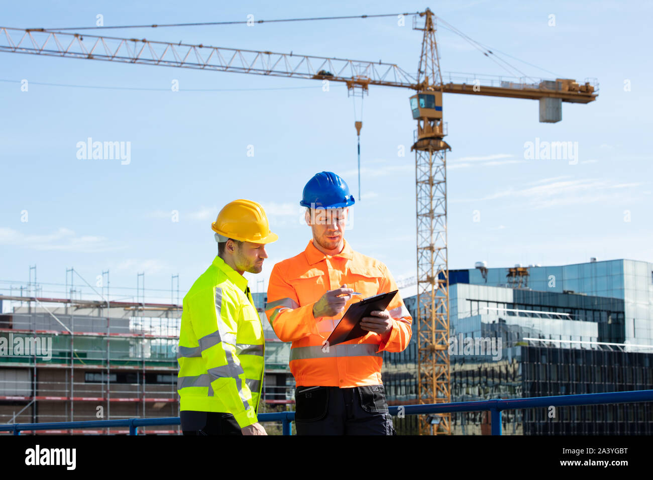 Male Architect Giving Instructions To His Foreman On Clipboard Working ...