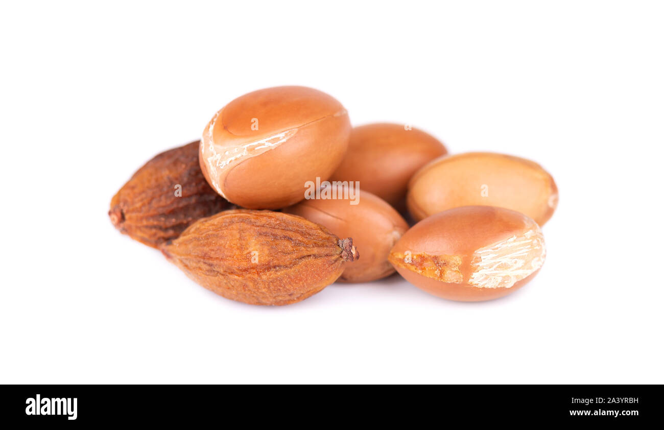 Argan seeds, isolated on a white background. Argan nuts and oil, for ...
