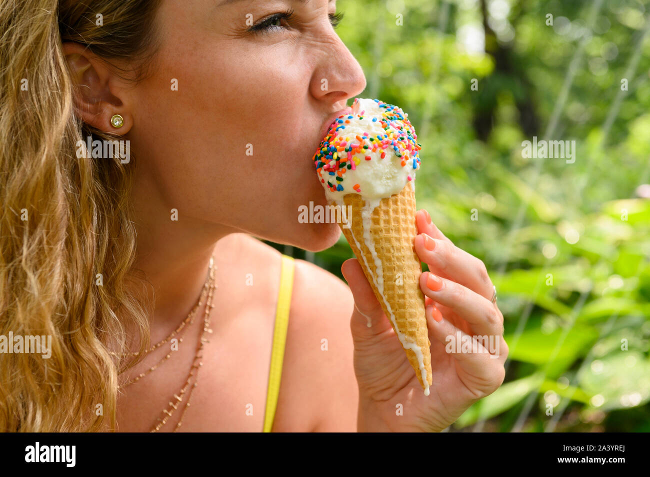 Young woman eating ice cream cone Stock Photo - Alamy