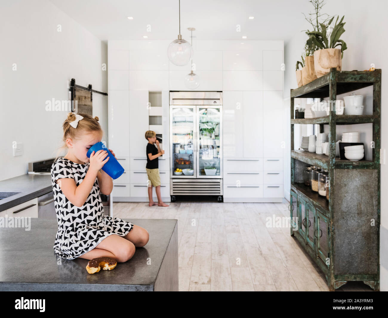 Girl drinking on kitchen counter Stock Photo - Alamy