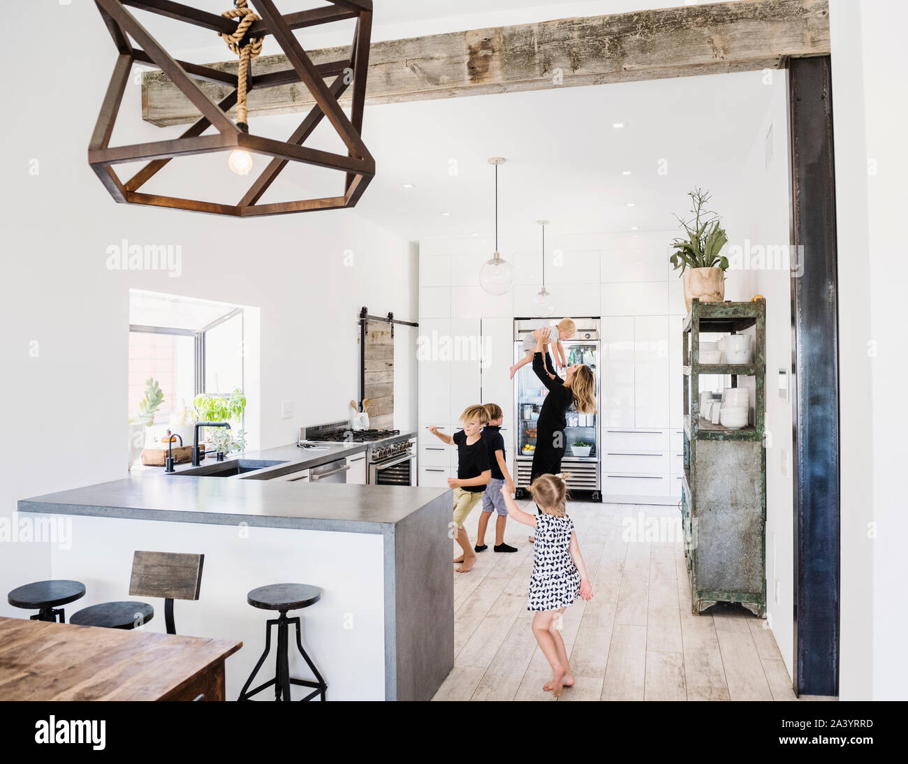 Mother and children in kitchen Stock Photo - Alamy