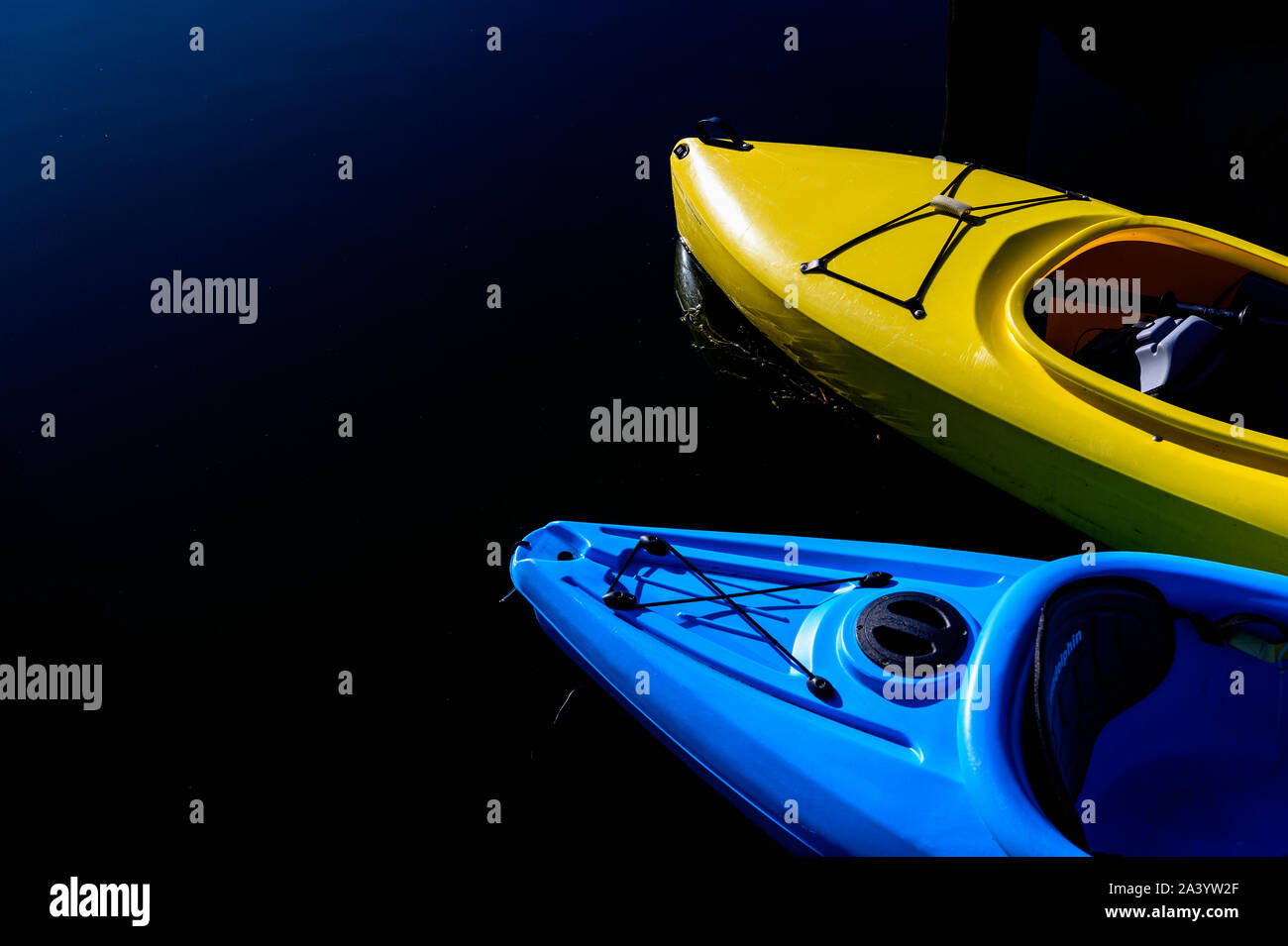 Yellow and blue kayaks on water Stock Photo - Alamy