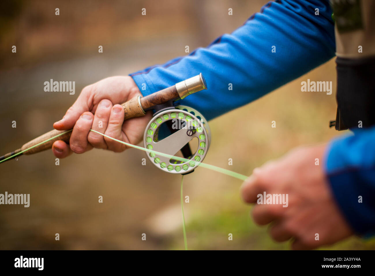 Man's hands holding fishing rod Stock Photo - Alamy