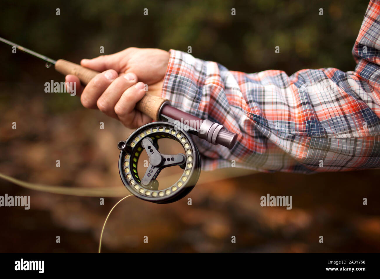 Hand of man holding fishing rod Stock Photo - Alamy