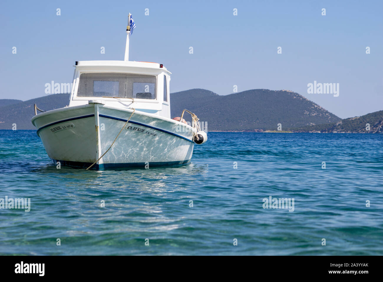 Small traditional style boat afloat and moored in blue Mediterranean ...