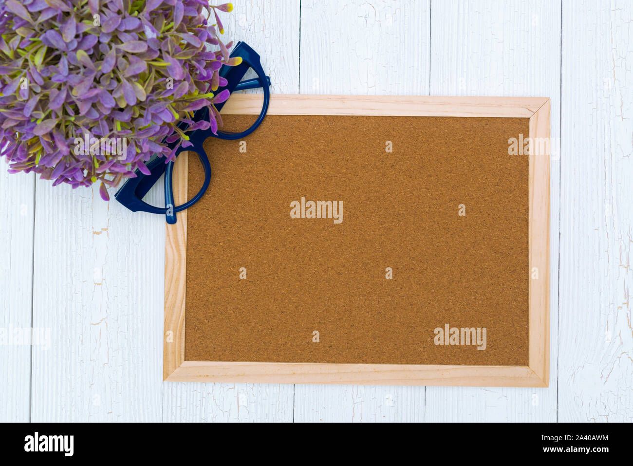 Empty cork board with little tree on wooden desk, top view with copy ...