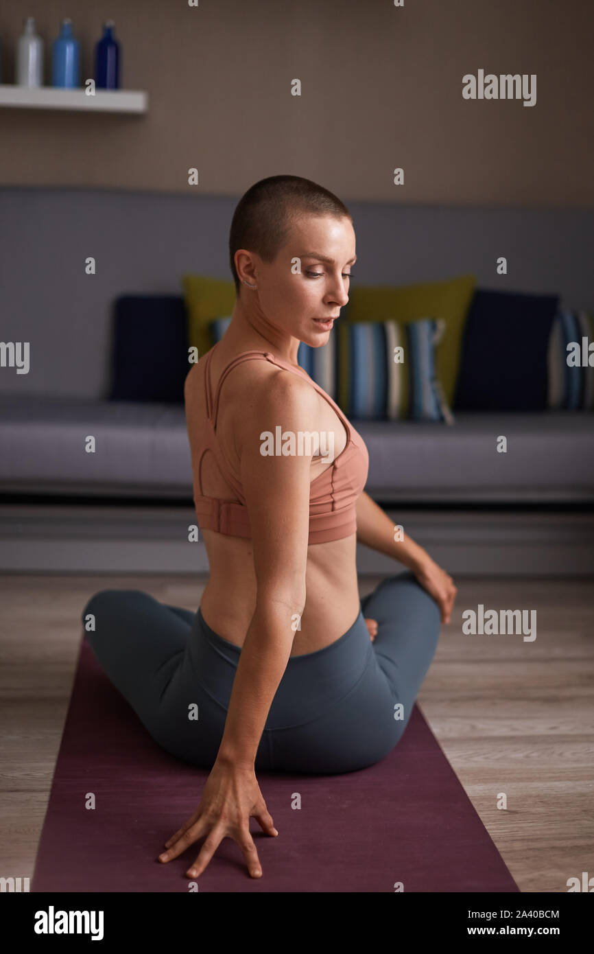 Fit caucasian woman sitting on mat and stretch muscles of body. Female ...