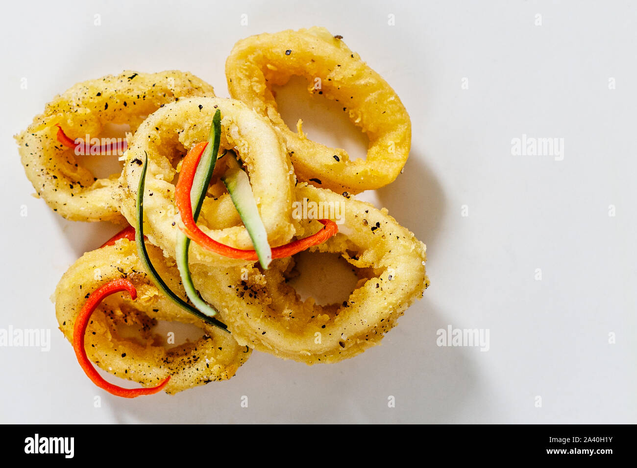 Pile of deep-fried calamari rings on the white background. Top view ...