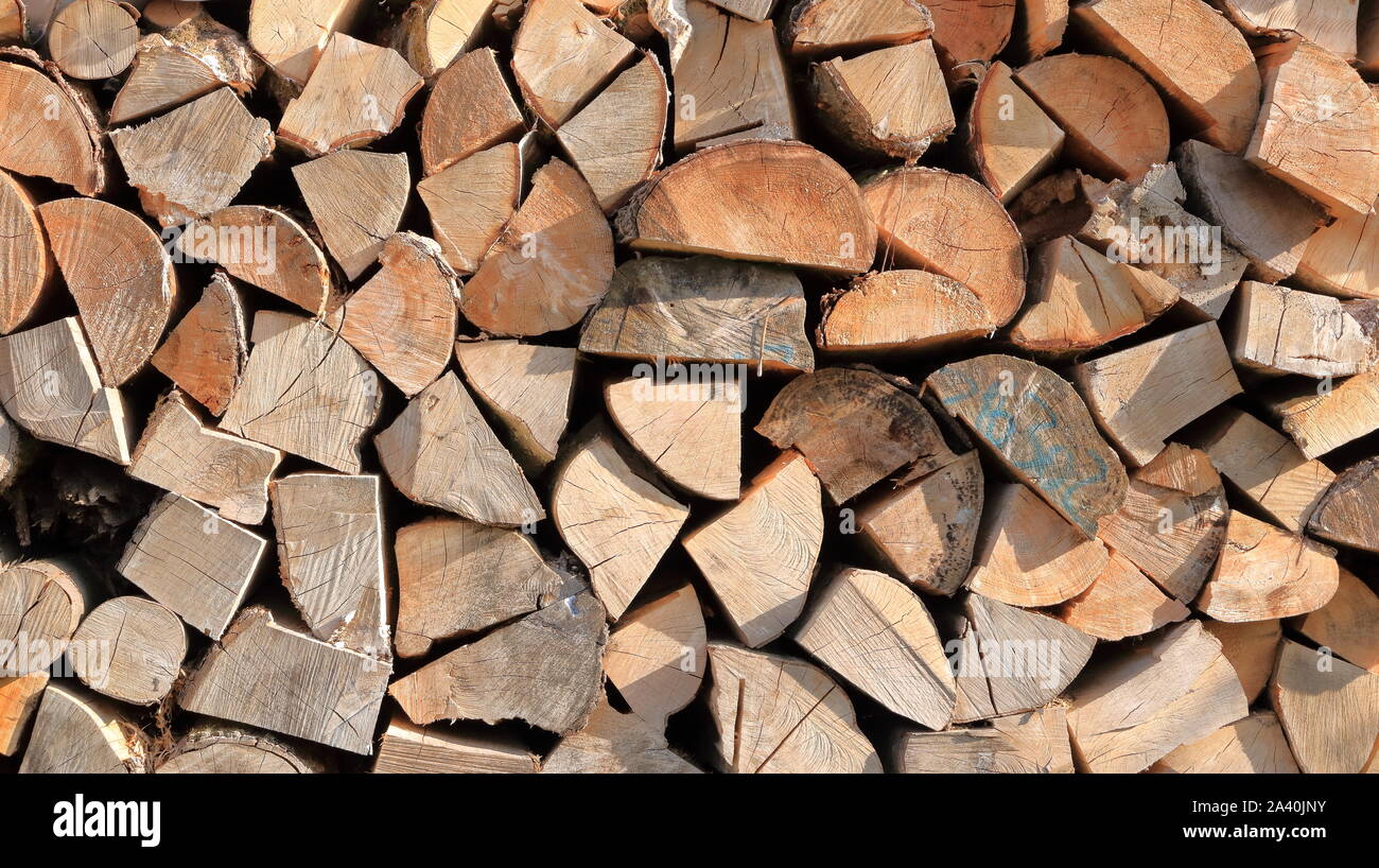 Stack of Wood wood stacked for drying in the woodpile on a green meadow ...