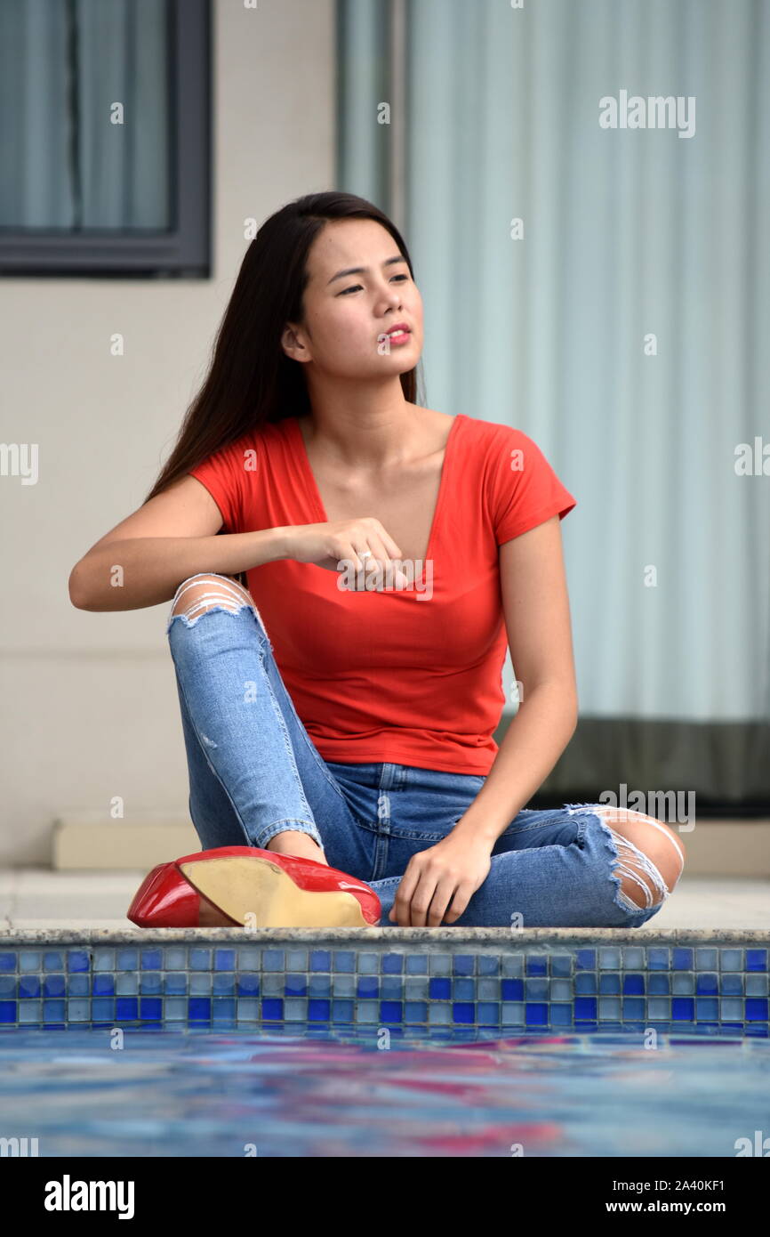 Thinking Beautiful Filipina Female Sitting At Condo Stock Photo - Alamy