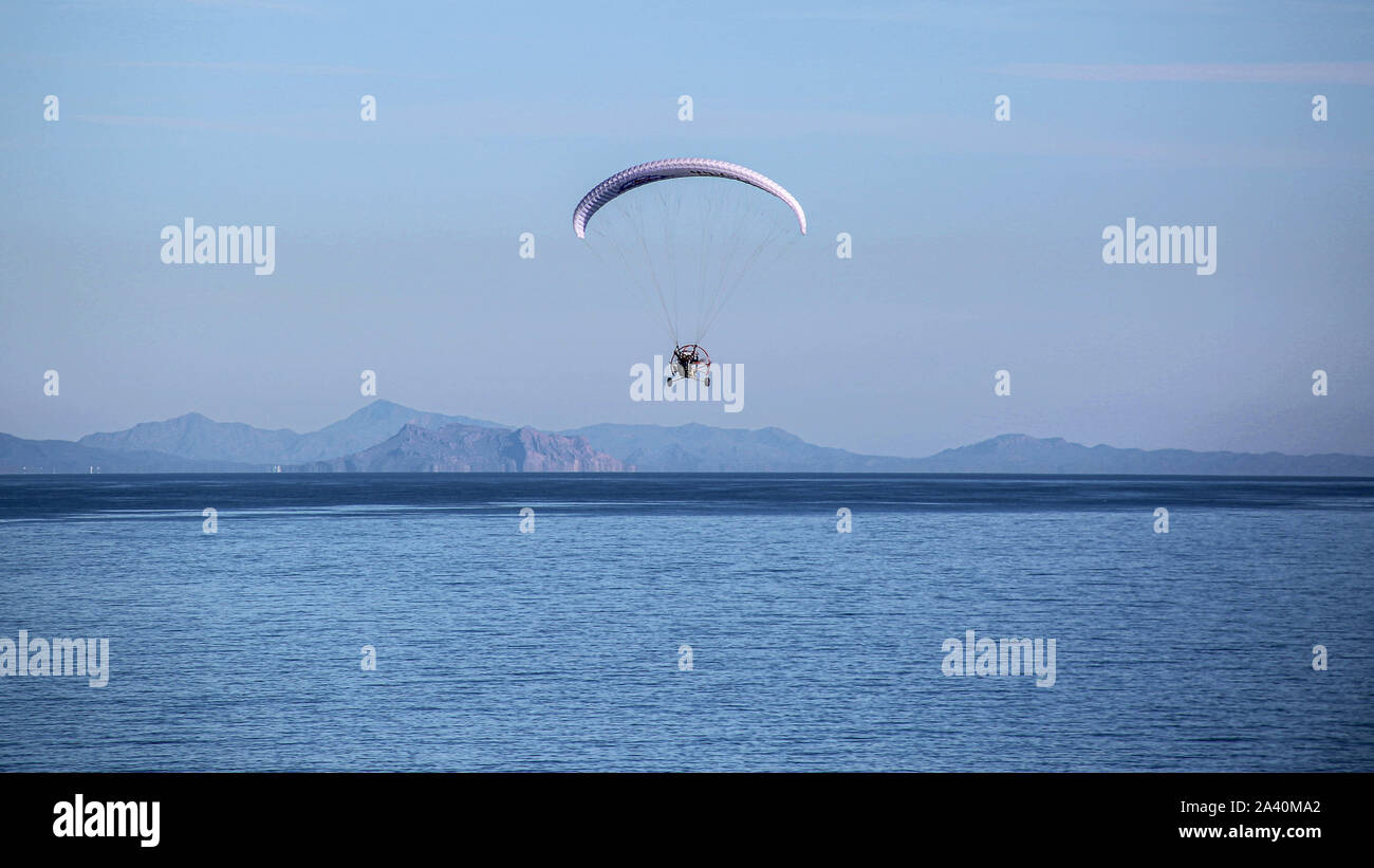 Paragliding over a Crystal Blue Sea Stock Photo - Alamy