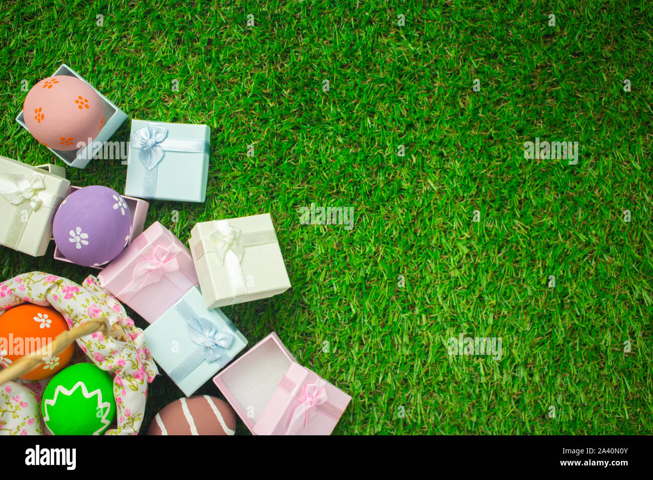 Top view easter eggs in a basket weave wood and gift box on the green ...