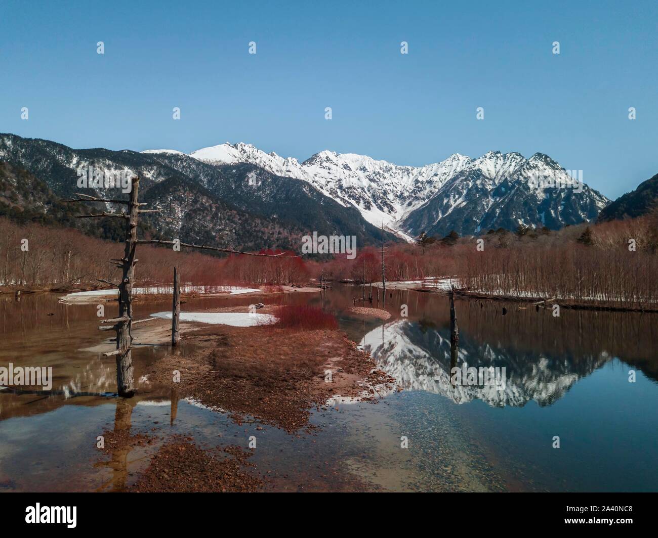 Snow-covered Japanese Alps reflected in Lake Taisho Pond, Kamikochi ...