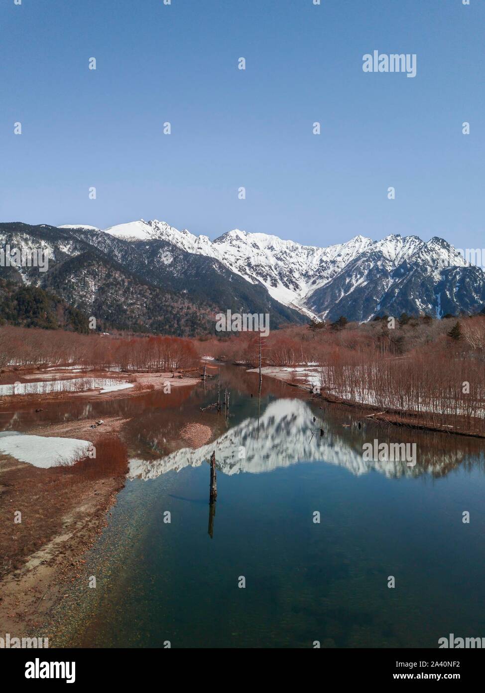 Snow-covered Japanese Alps reflected in Lake Taisho Pond, Kamikochi ...