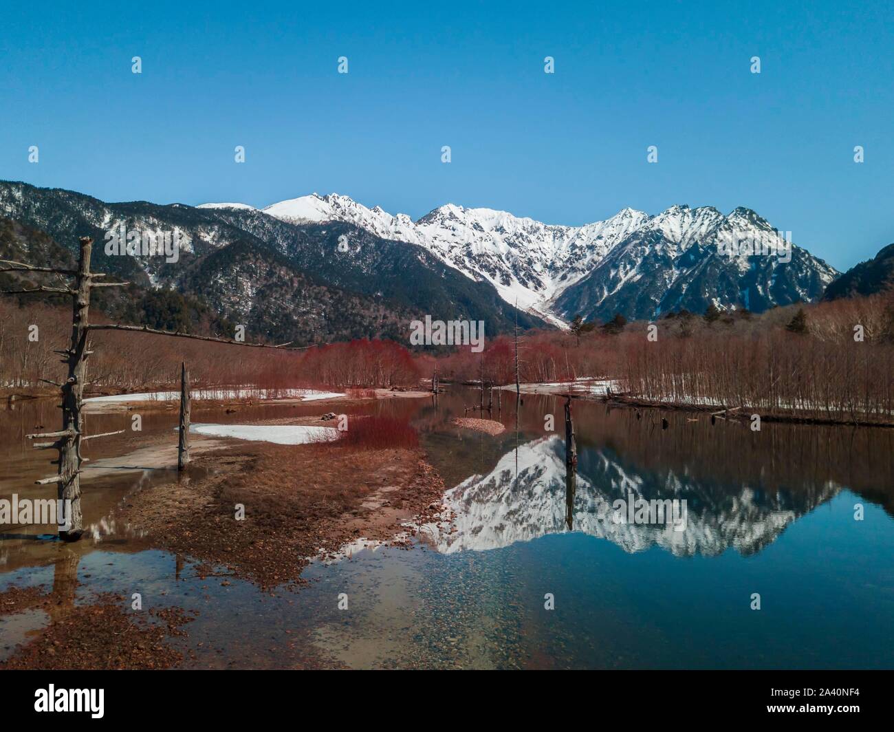 Snow-covered Japanese Alps reflected in Lake Taisho Pond, Kamikochi ...