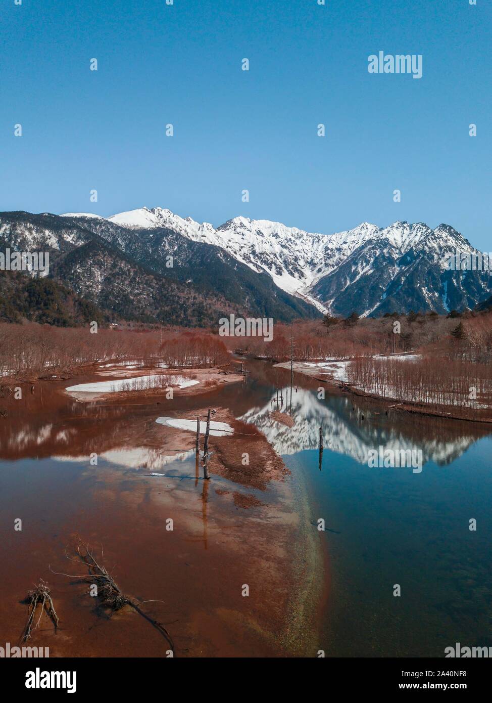 Snow-covered Japanese Alps reflected in Lake Taisho Pond, Kamikochi ...