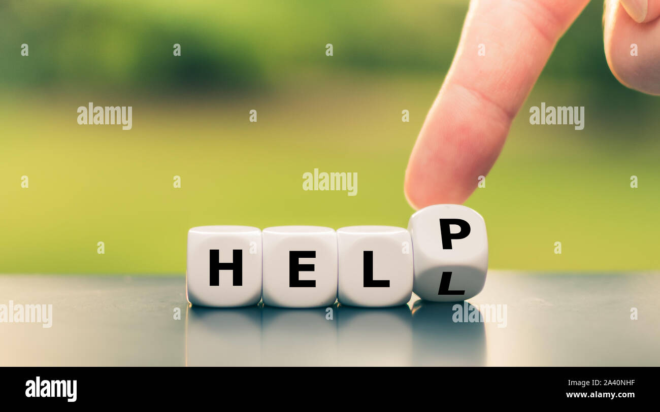 Getting help concept. Hand turns a dice and changes the word "hell" to ...