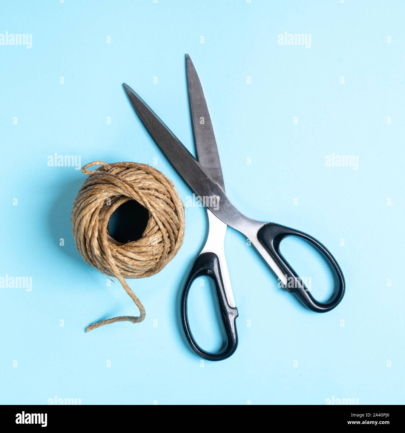 a ball of string and a pair of scissors on a white surface Stock Photo ...