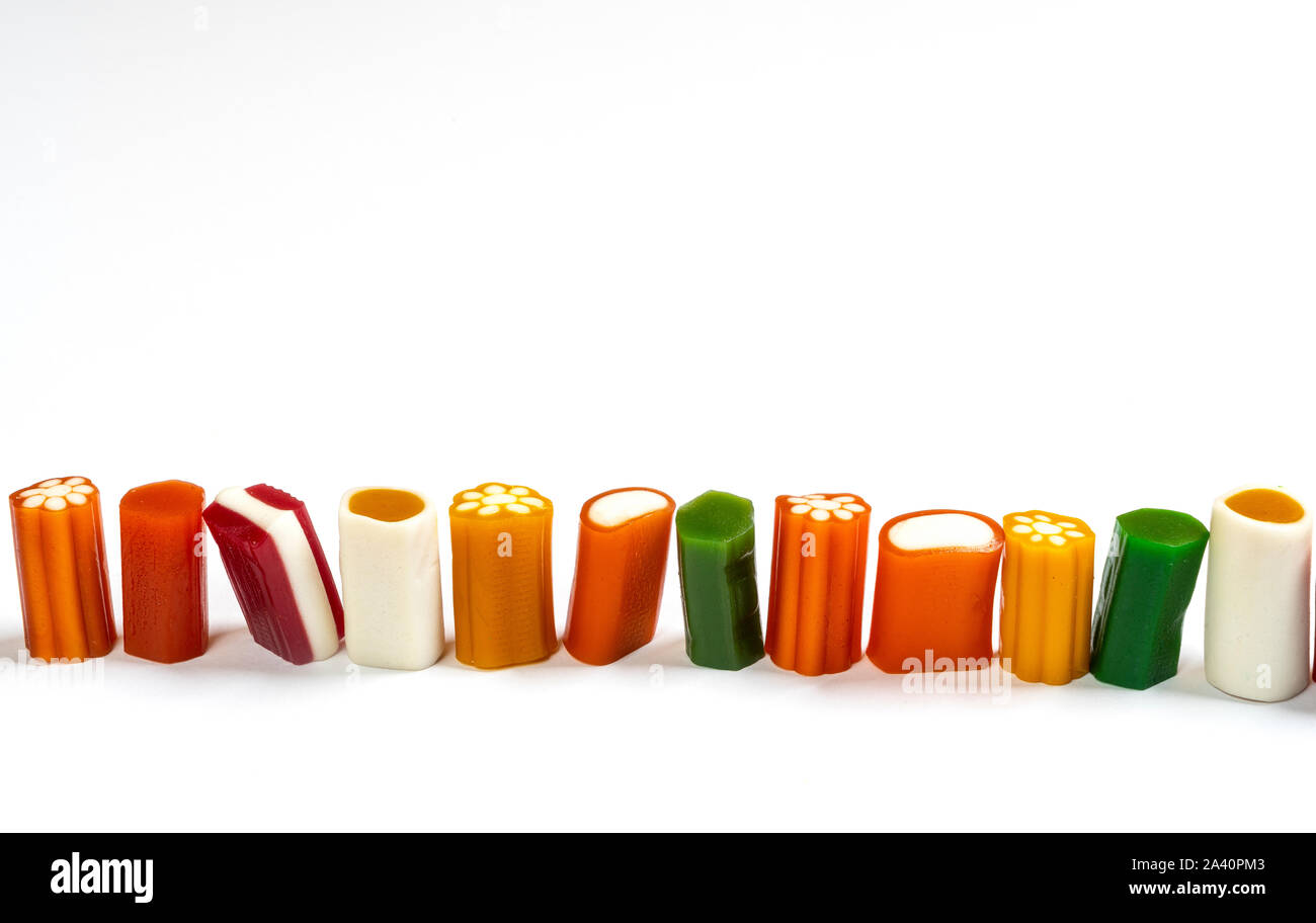 a row of colorful candies of various shapes on a white surface Stock ...