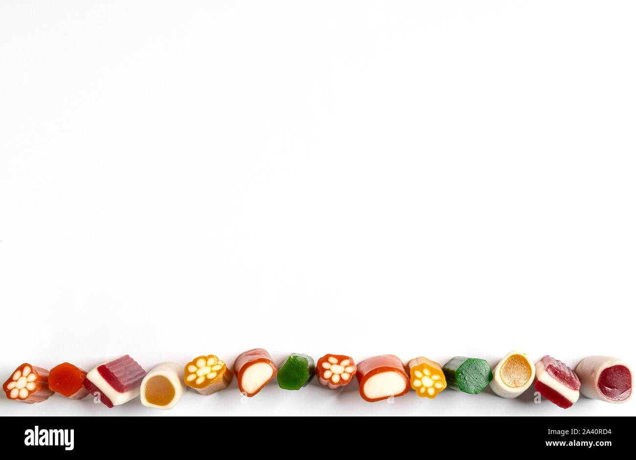 a row of colorful candies of various shapes on a white surface Stock ...