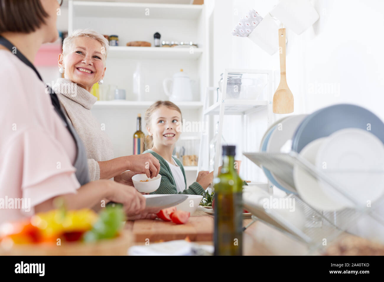 Grandmother and little girl standing and smiling to mother while ...