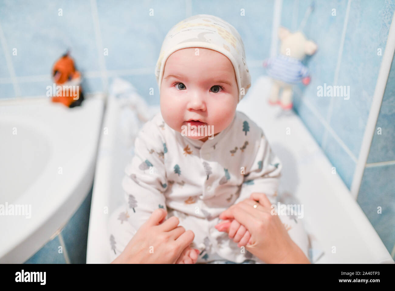mom holds the arms of a small child. for two little hands. supporting ...