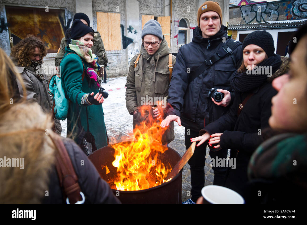 People try to stay warm around a fire at the Hipster Winter Olympiale ...