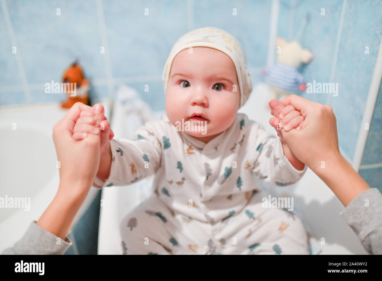 mom holds the arms of a small child. for two little hands. supporting ...
