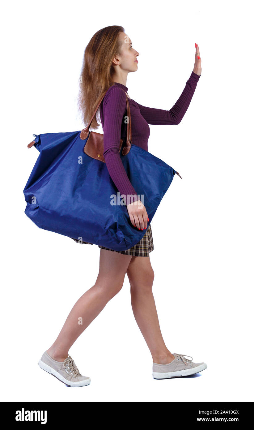 Back view of a woman who comes with a bag welcomes someone with hand ...