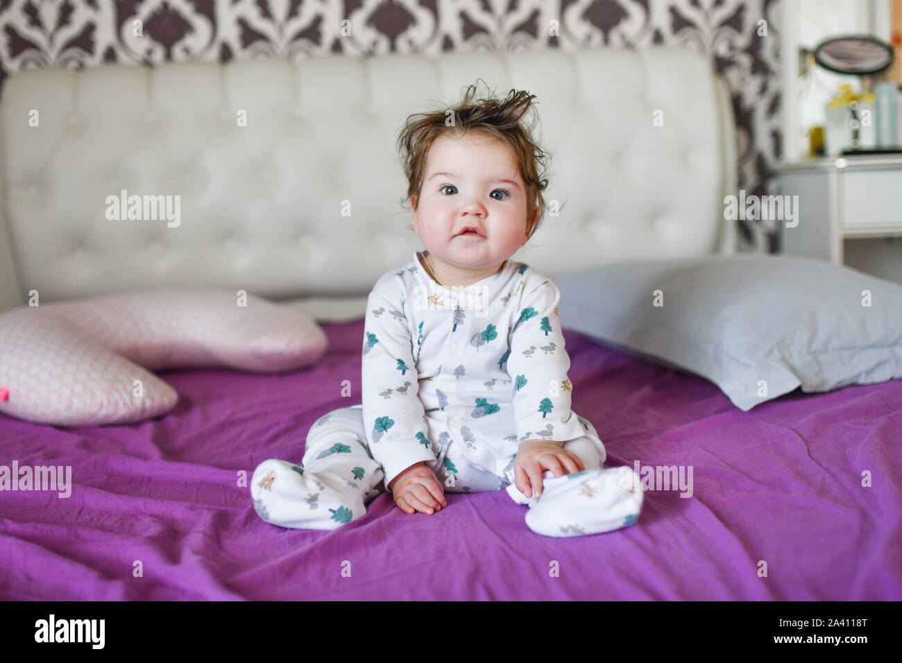 portrait of a small child sitting on the bed. Portrait of a little baby ...