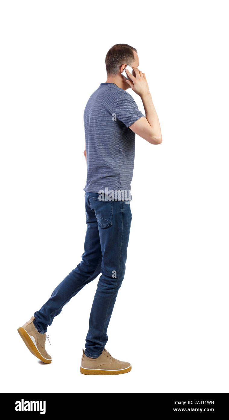 a side view of man walking with a mobile phone. backside view of person ...