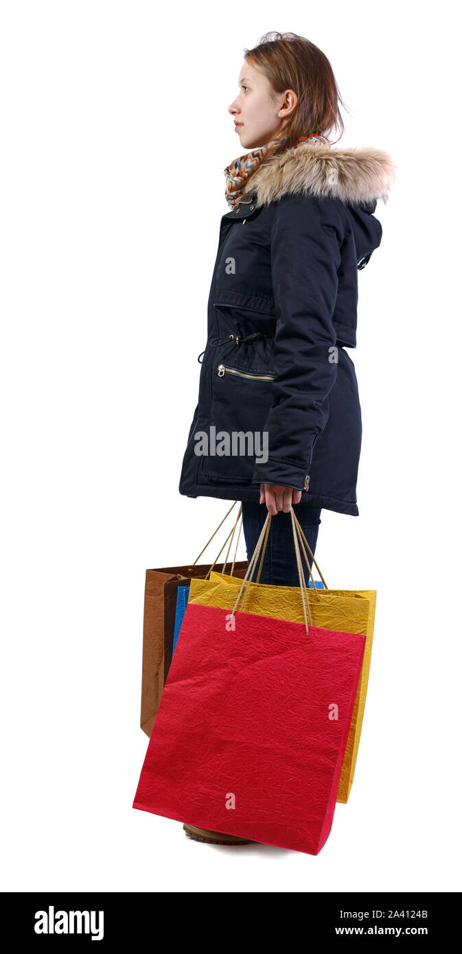 Side view of woman in winter jacket with shopping bags. backside view ...