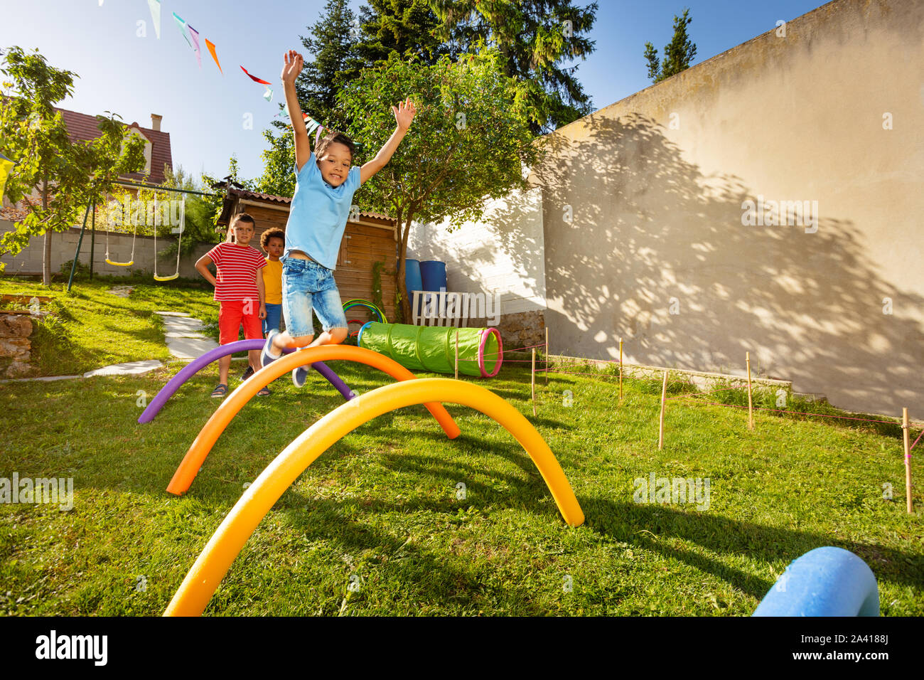 Race game with obstacles kids jump over barrier Stock Photo - Alamy