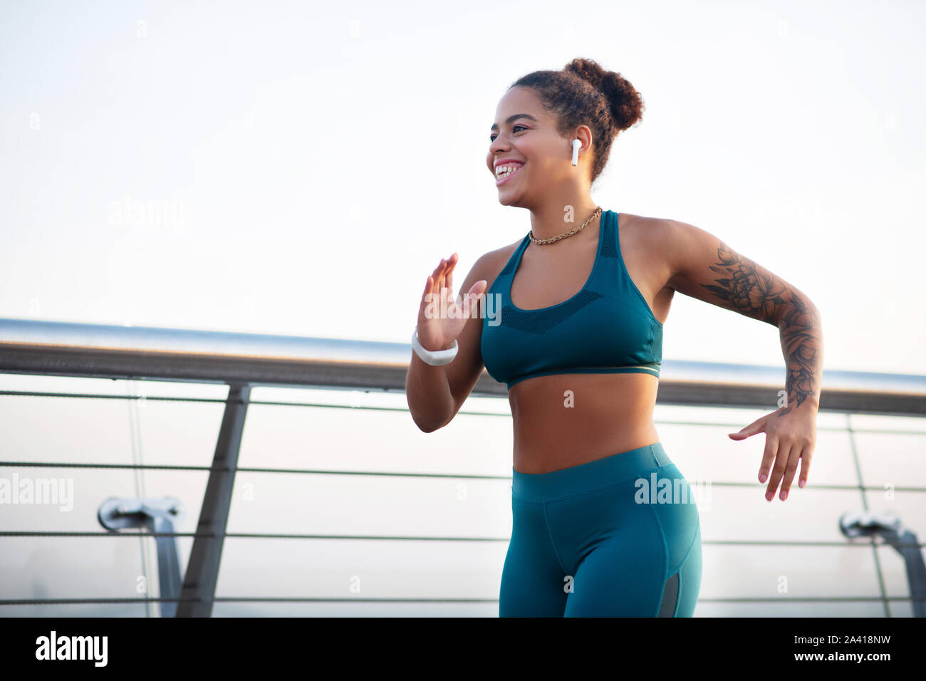Excited tattooed woman running fast in the morning Stock Photo - Alamy