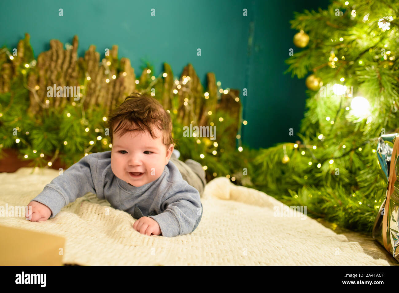 A child near the Christmas tree. Little boy celebrating christmas. baby ...