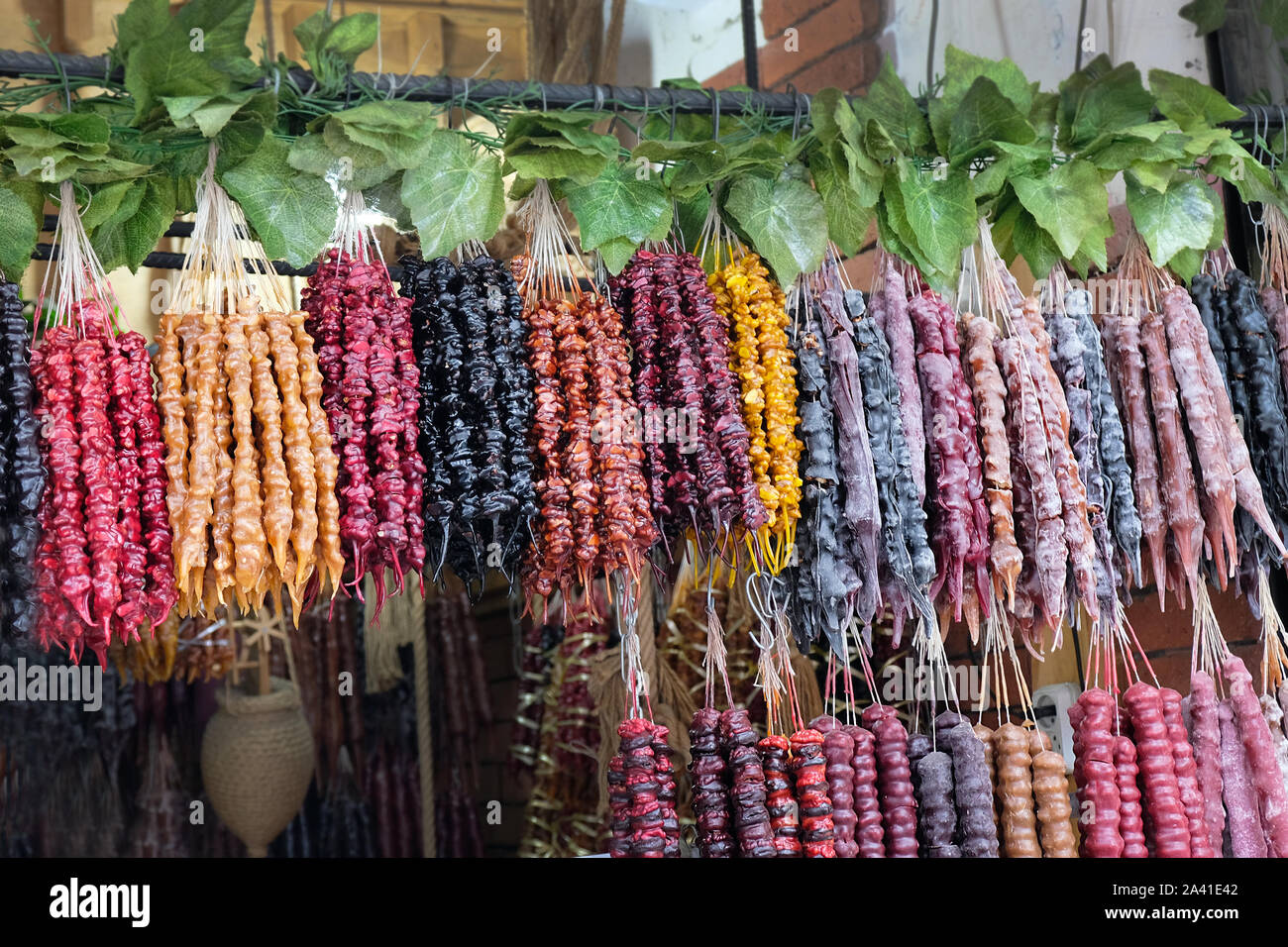 Churchkhela with walnuts red, yellow and brown hanging on a thread on ...