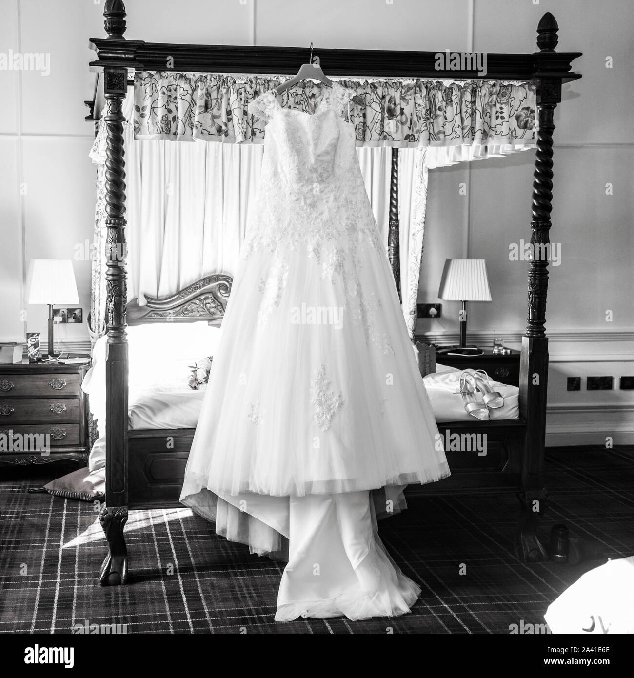 Brides wedding dress hanging on a four poster bed on her wedding day ...