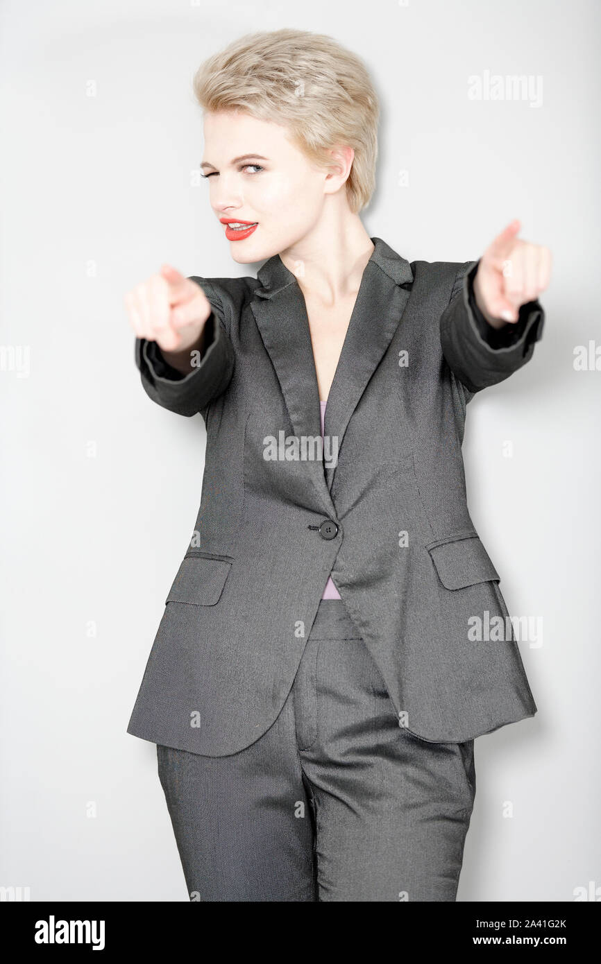 Professional business woman pointing and winking Stock Photo - Alamy