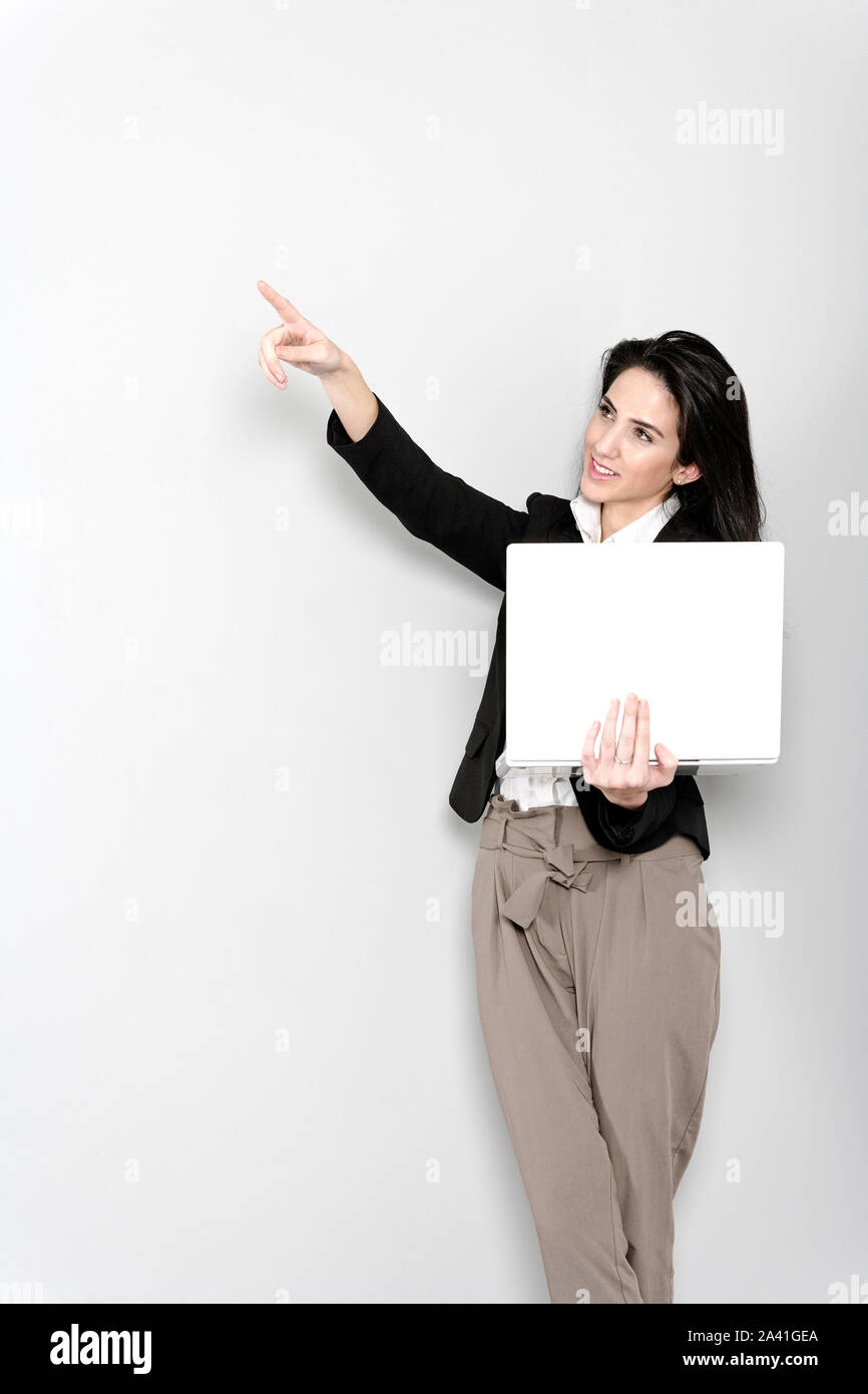 Professional business woman with laptop pointing Stock Photo - Alamy