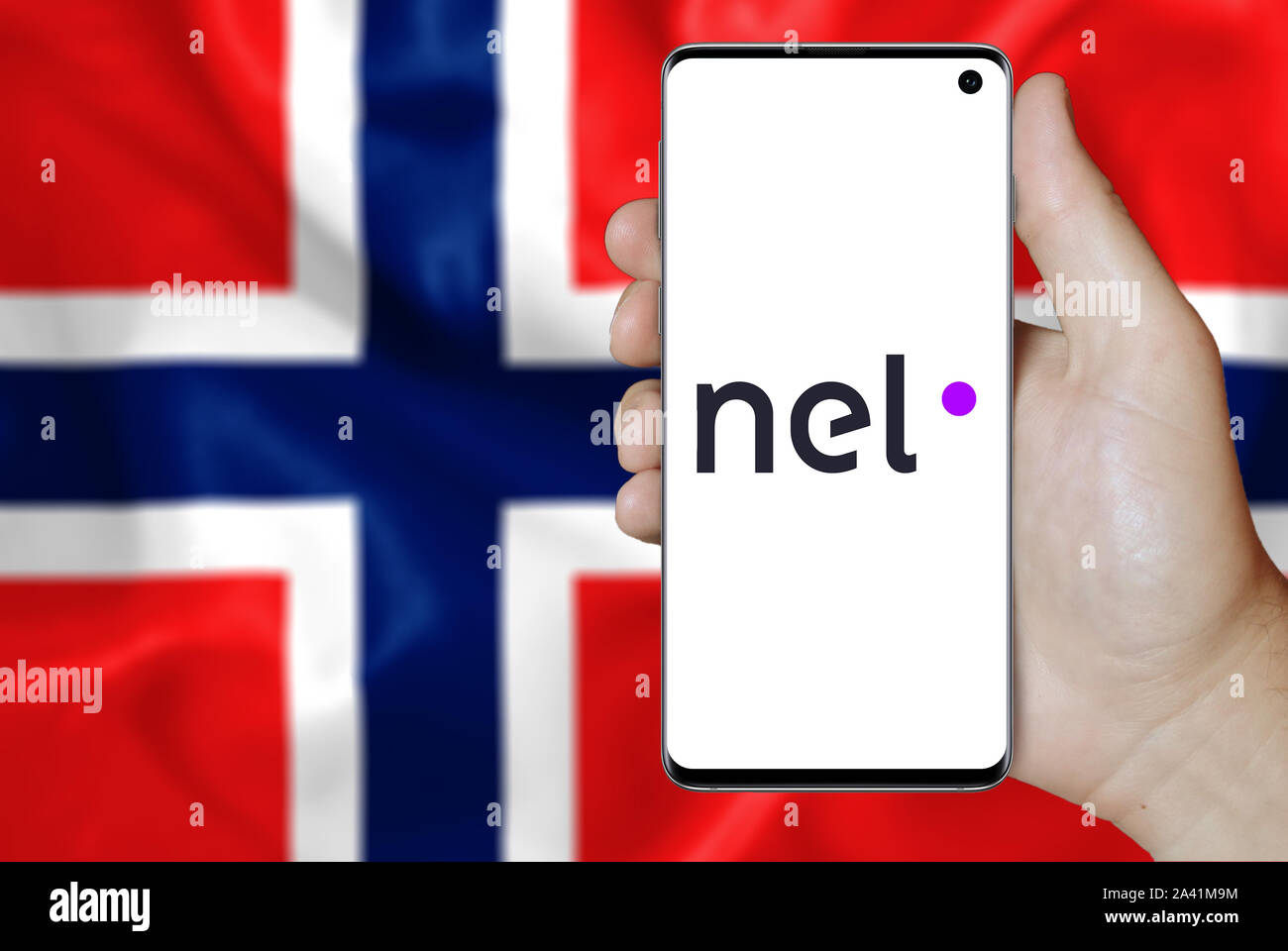 A man holds a phone displaying the logo of company NEL listed on Oslo ...