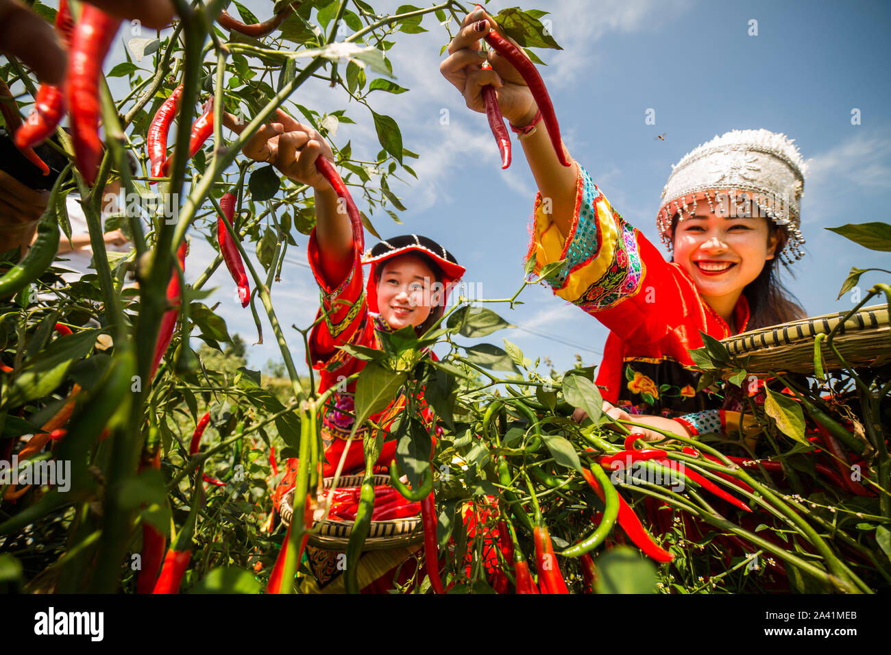 Young Chinese villagers dressed in traditional costumes of Yi ethnic ...