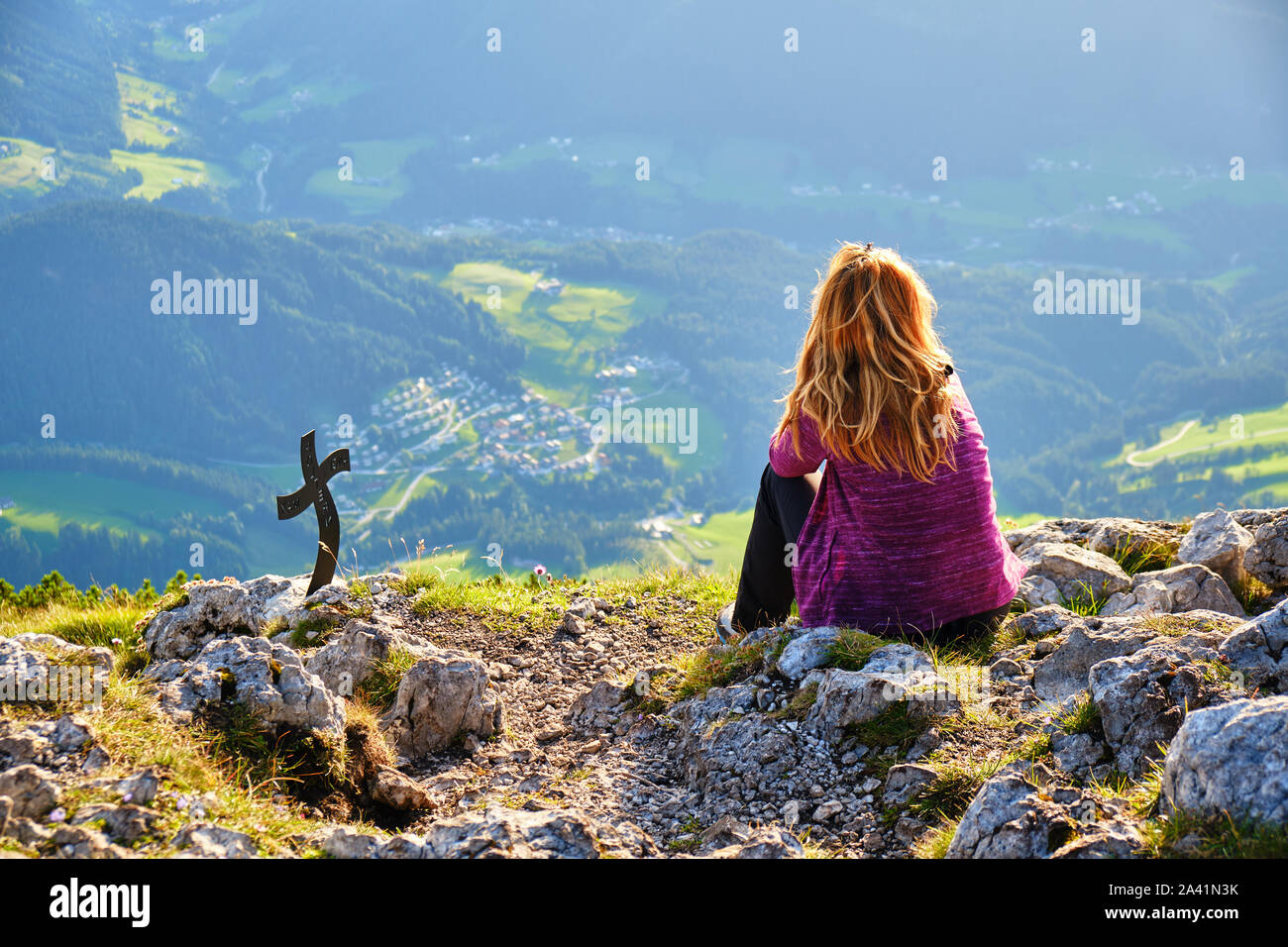Woman near a cross on top of Donnerkogel mountain peak, Austria ...